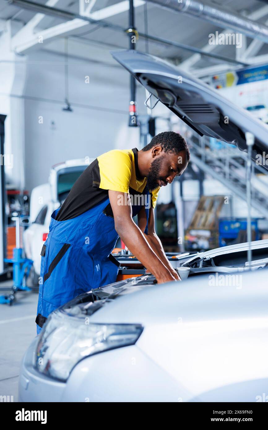 Engineer expertly examines car motor using advanced mechanical tools ...