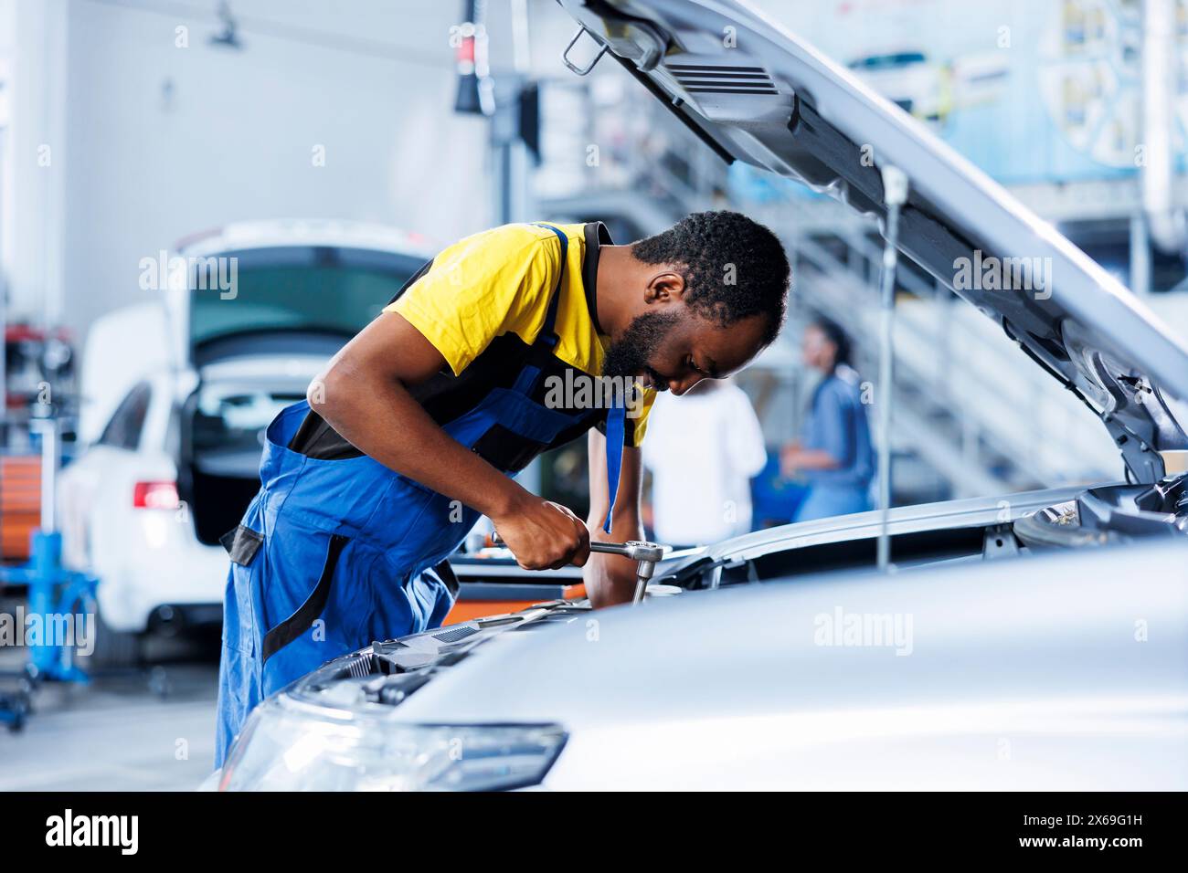 Engineer expertly examines car brakes using advanced mechanical tools ...