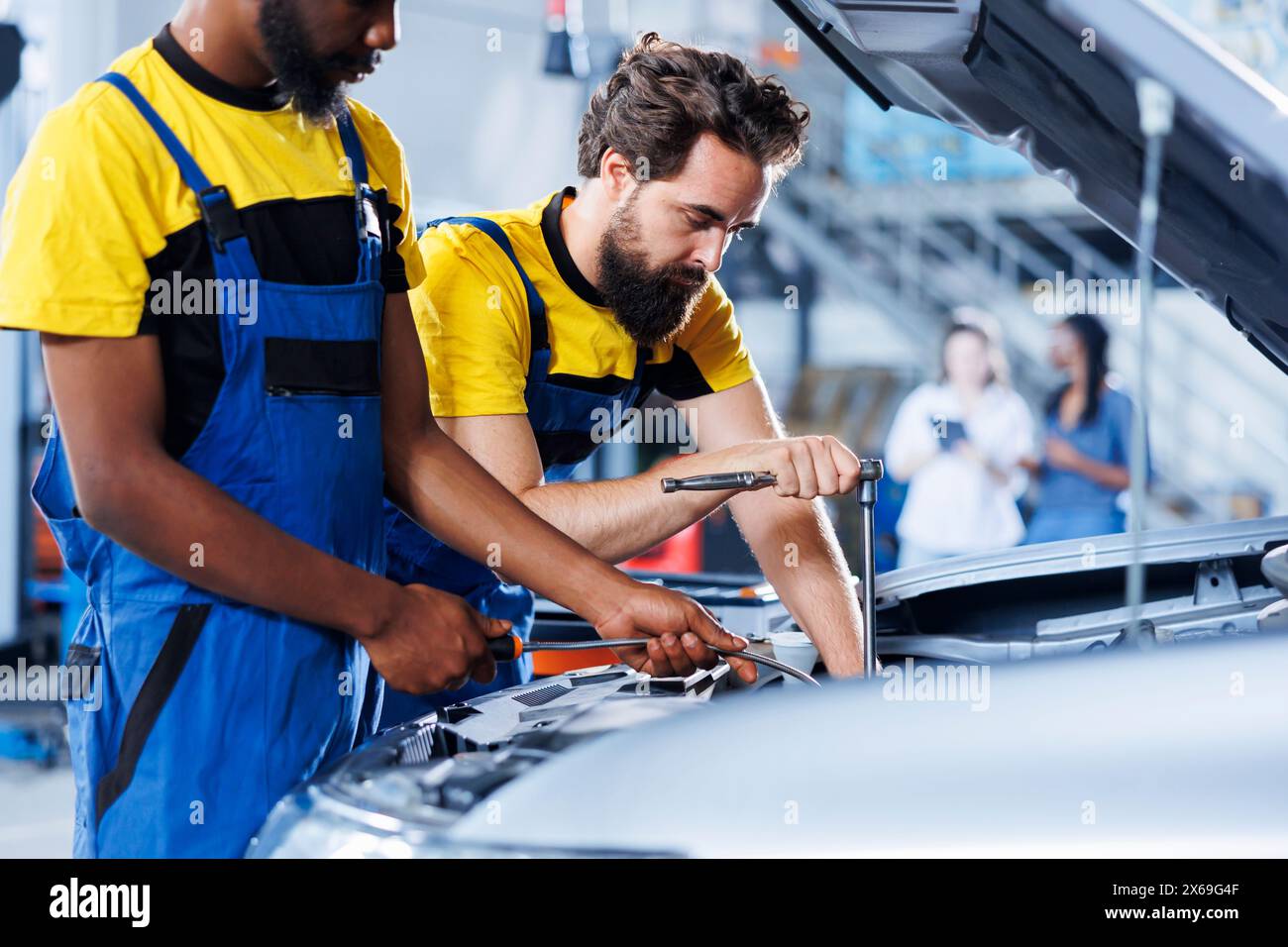 Teamworking coworkers using oil extractor tool to change old ...