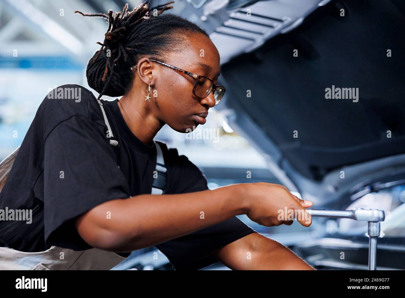 Repair shop technician examines damaged car motor using advanced ...