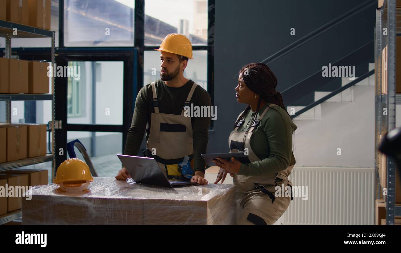Dolly out shot of employees running warehouse inventory investigation ...