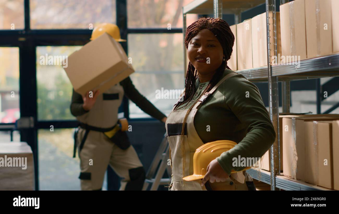 Portrait of cheerful african american warehouse sorter in protective ...