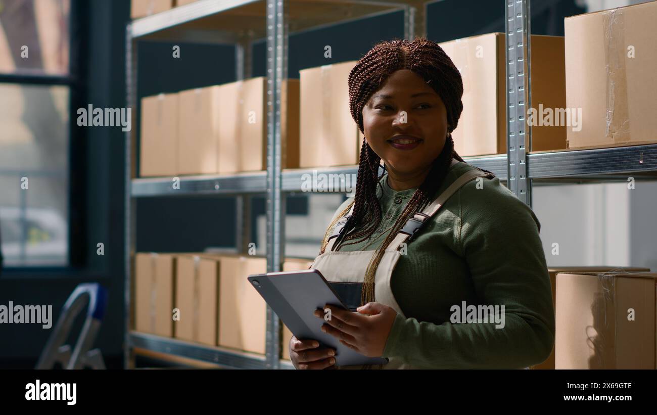 Portrait of joyful warehouse chief supply chain officer holding tablet ...