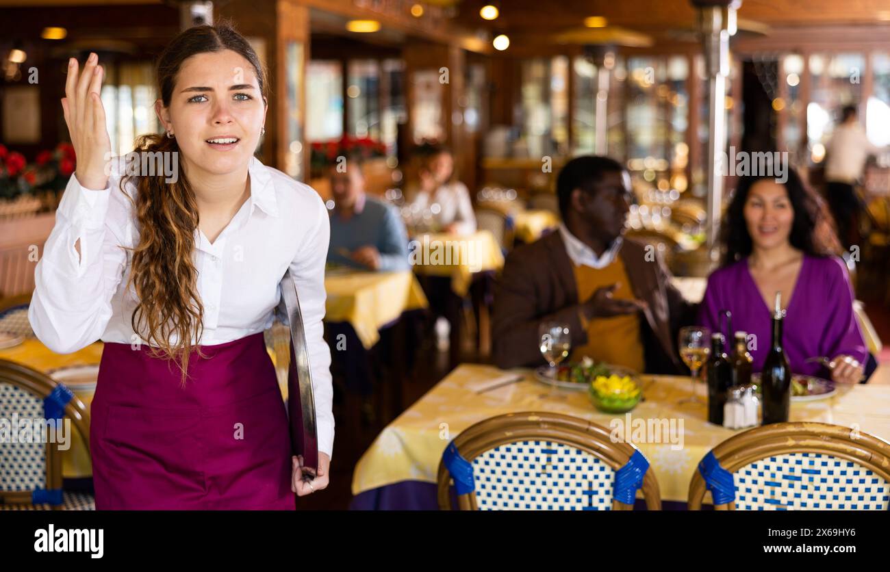 Stressed young waitress fed up with work standing in restaurant Stock ...