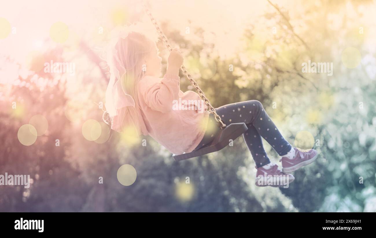 joyful little girl ascends into sunny sky on swing, blurred child ...