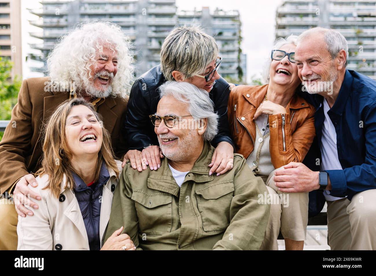 Happy group of senior people laughing while sitting together outdoors ...