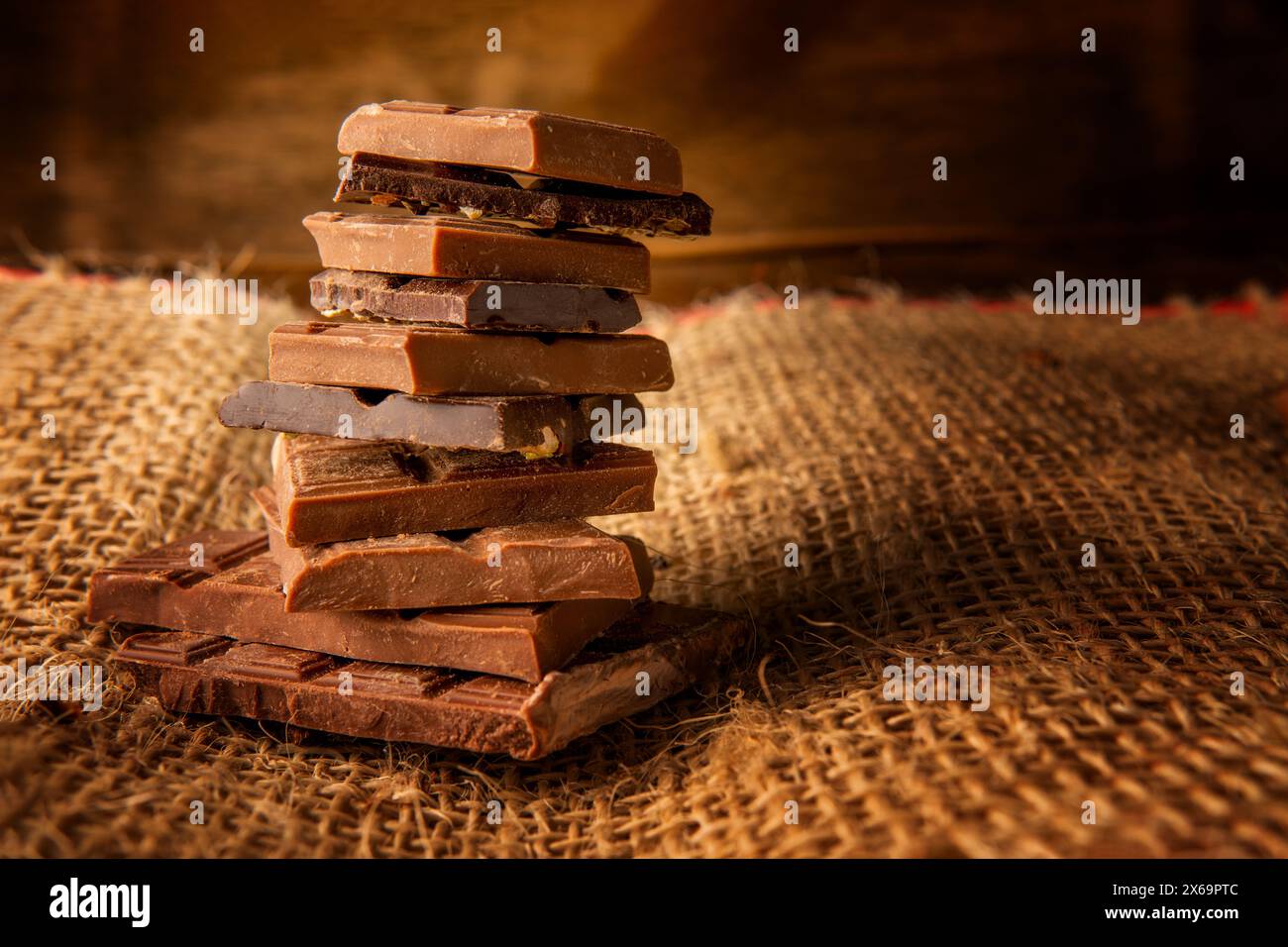 Column of chocolate pieces on a rustic background with copy space on a ...