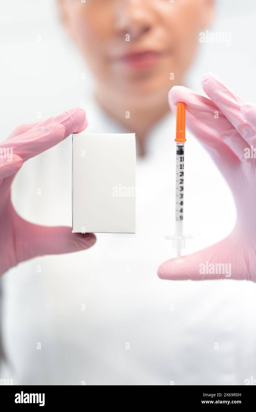 Female cosmetologist in pink gloves showing skin lifting injection and ...