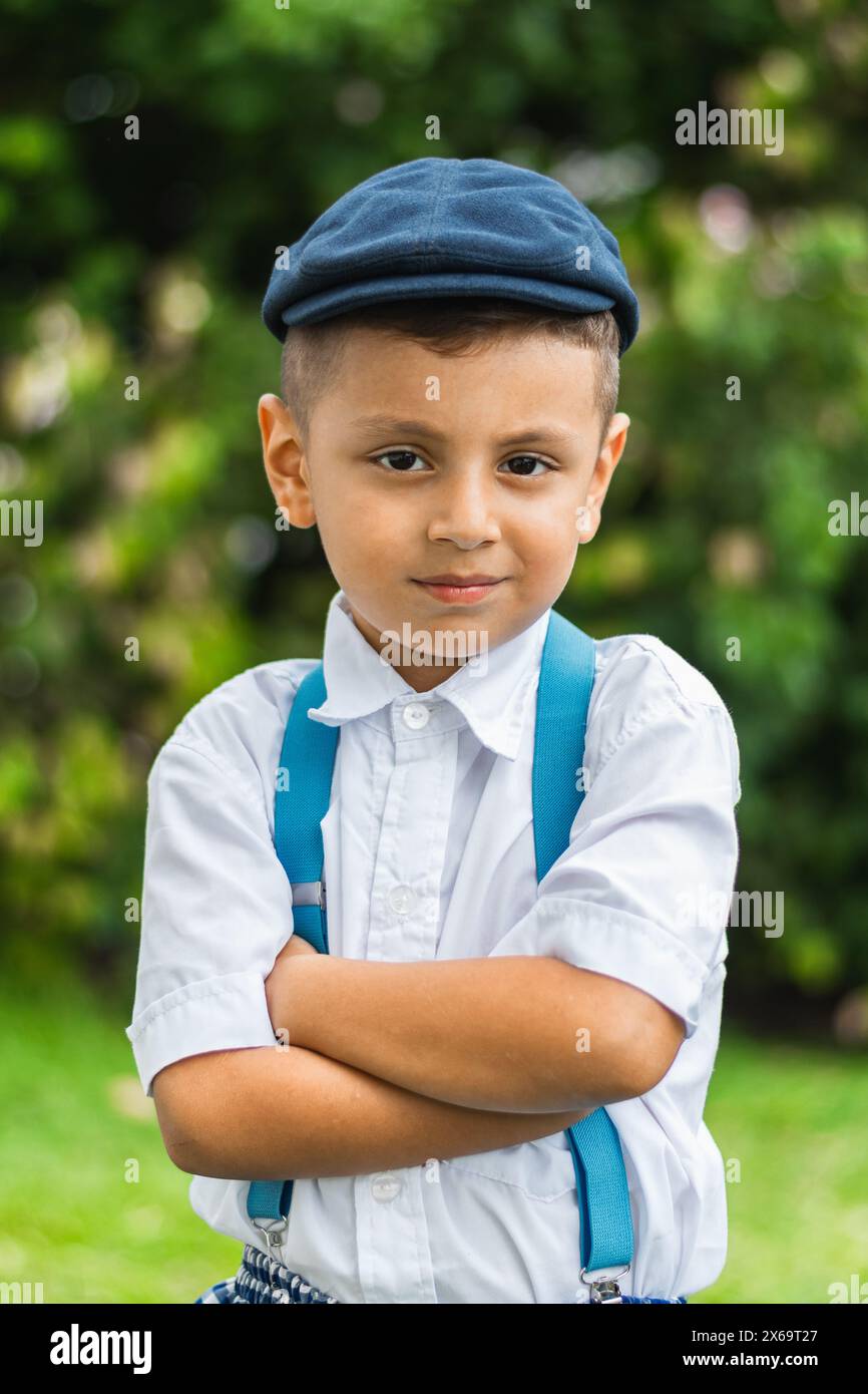 portrait of little latin boy looking serious with his arms crossed ...