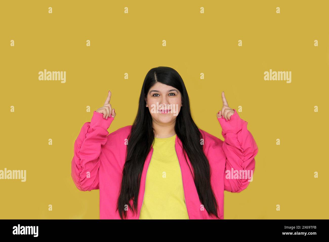 Latina 30 year old woman points finger at copy space for promotions and ...