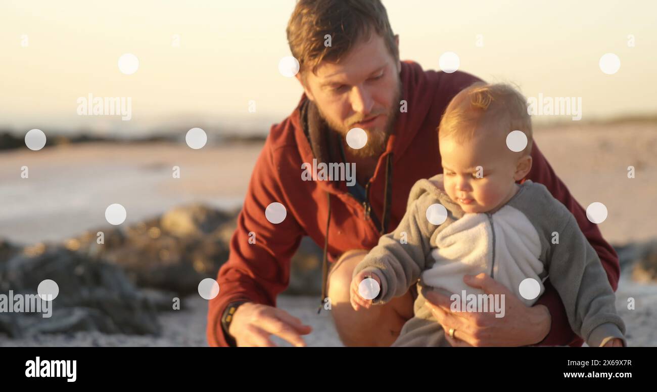 Image of white spots falling over caucasian father with baby Stock ...