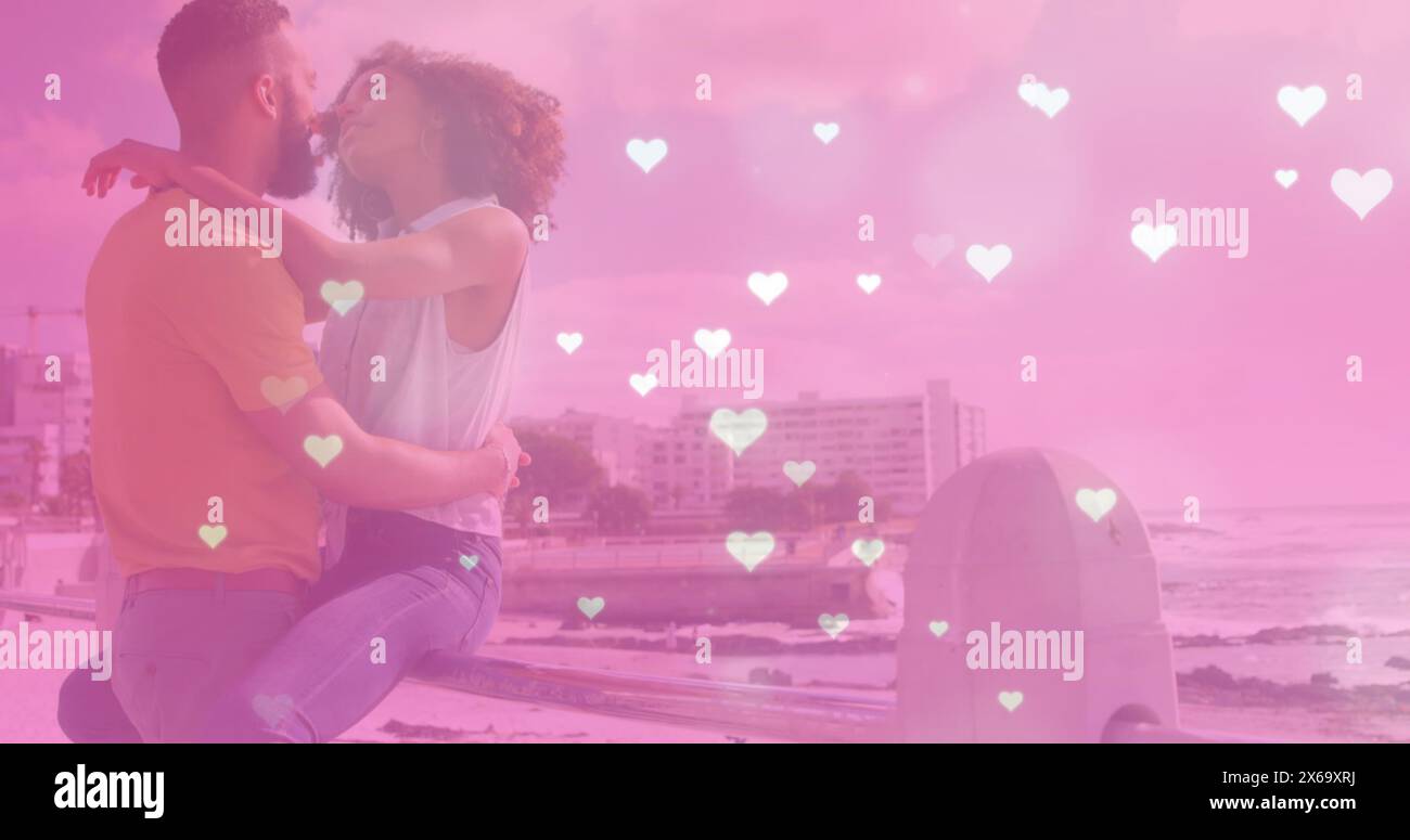 Image of heart icons over biracial couple at beach Stock Photo - Alamy