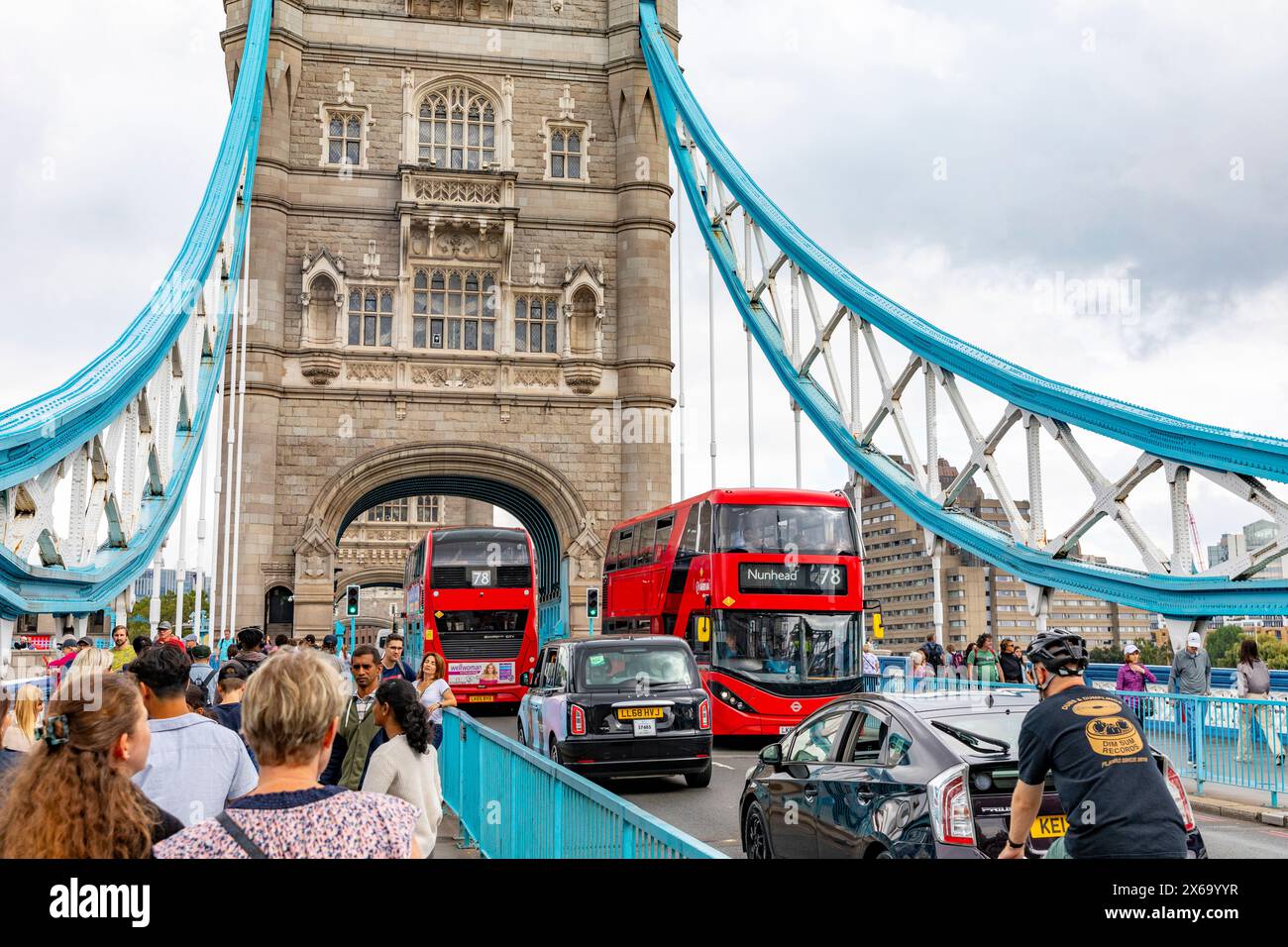 Tower Bridge London, pedestrian tourists walk across the bridge beside ...