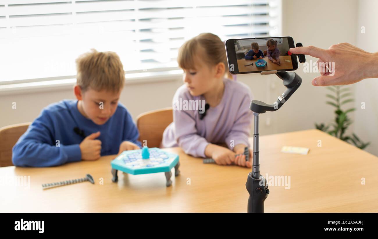 Kids play a new board game for their blog, recording a fun and ...
