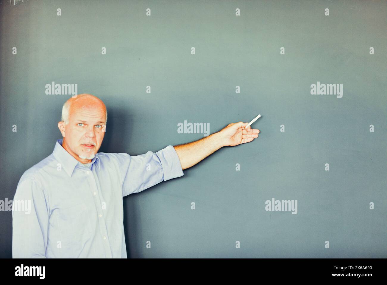 Annoyed elderly man holds a marker, expressing irritation over an ...