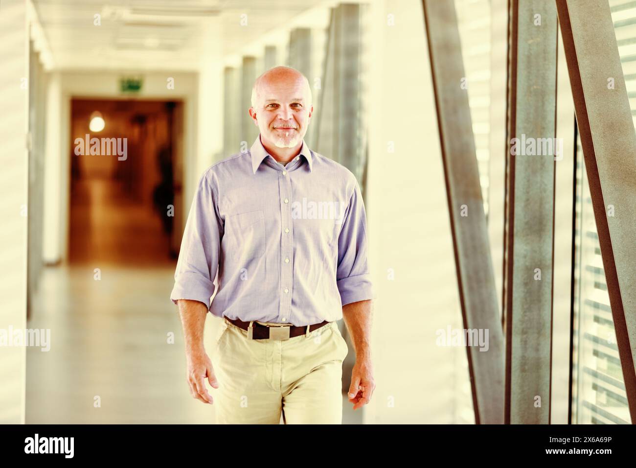 Senior man with a calm demeanor walks confidently through a modern ...