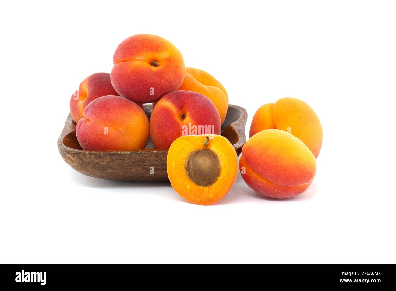 Group of fresh whole apricots and one cut in half to reveal its ...