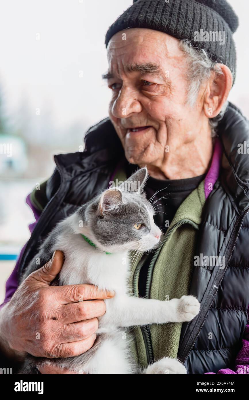 Old Russian man holding his cat and smiling Stock Photo - Alamy