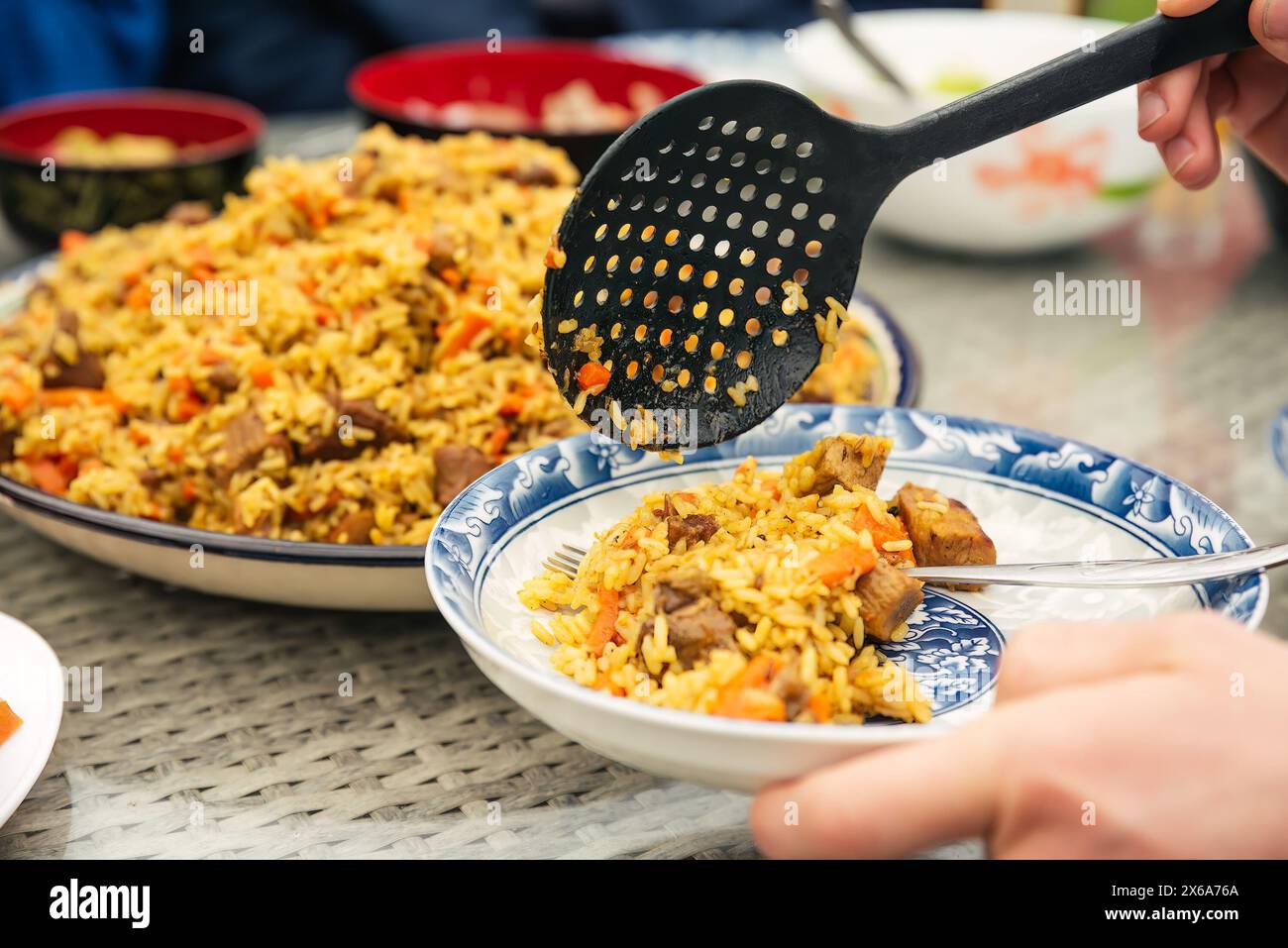 man putting a spoon national dish of oriental cuisine of Central Asian ...
