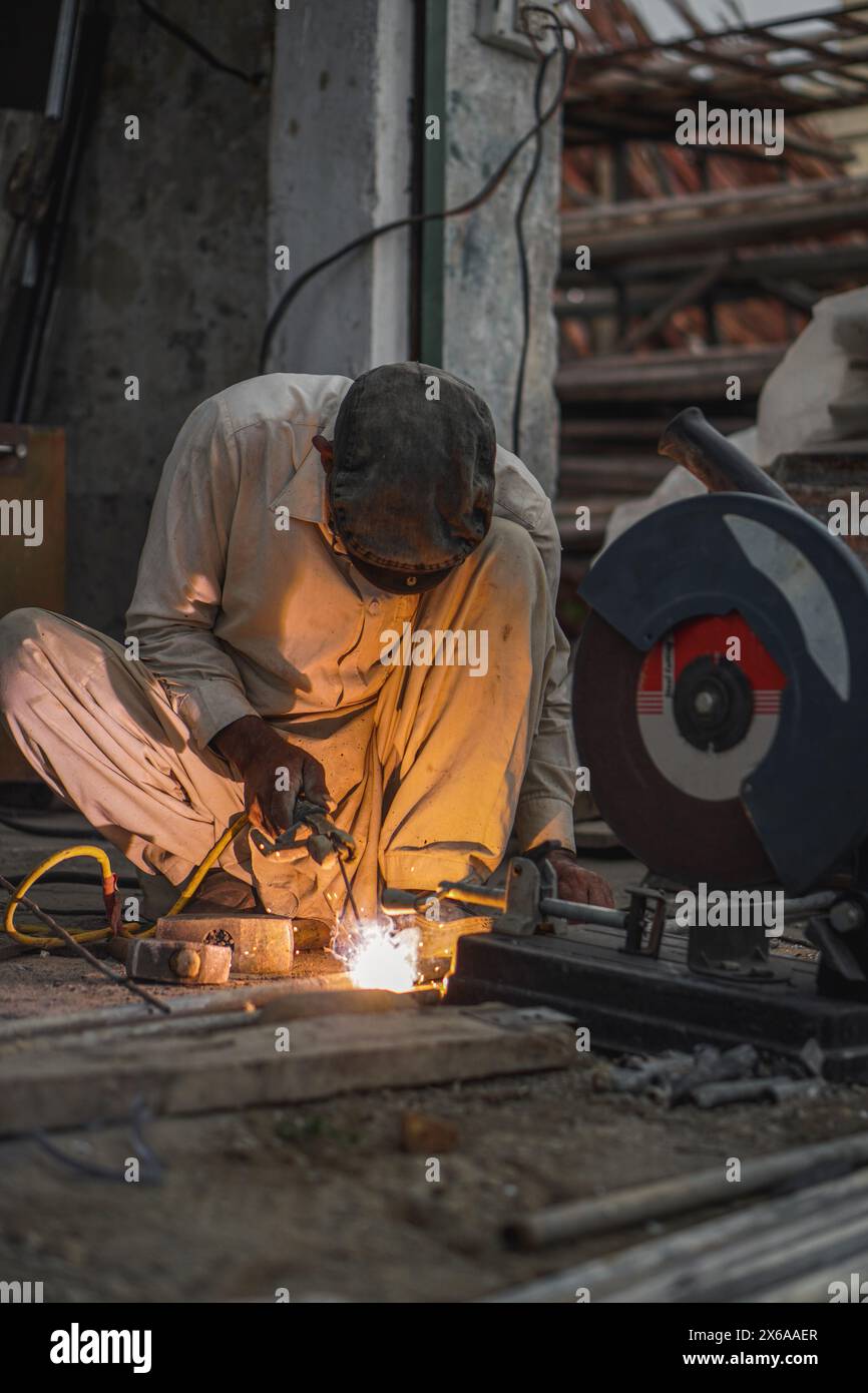 Poor old skilled Pakistani Welder welding pipes and metal rods in his ...