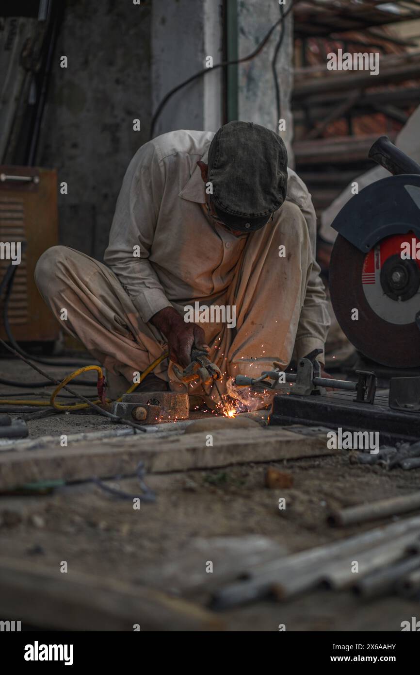 Poor old skilled Pakistani Welder welding pipes and metal rods in his ...