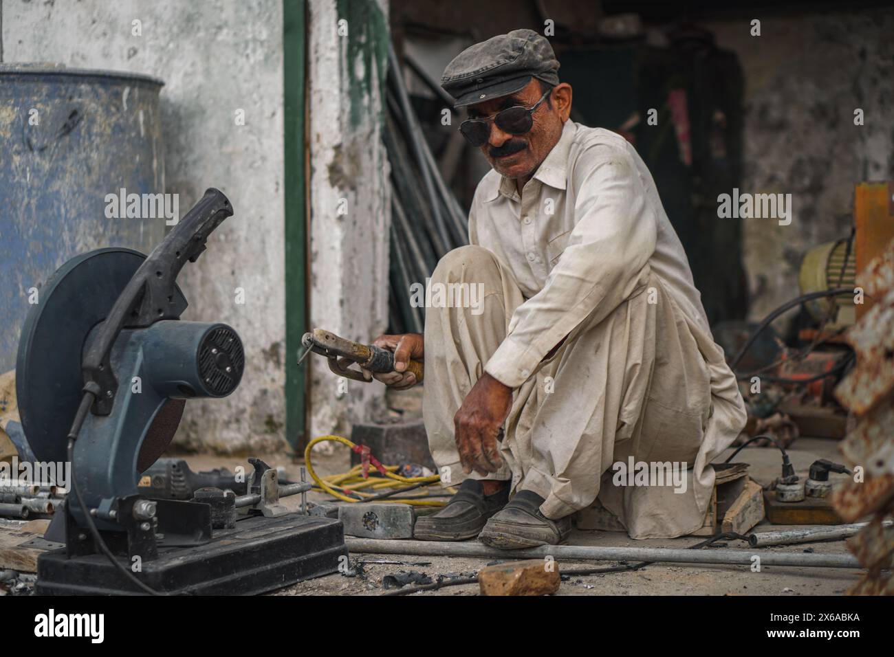 Poor old aged Pakistani welder working in his workshop Stock Photo - Alamy