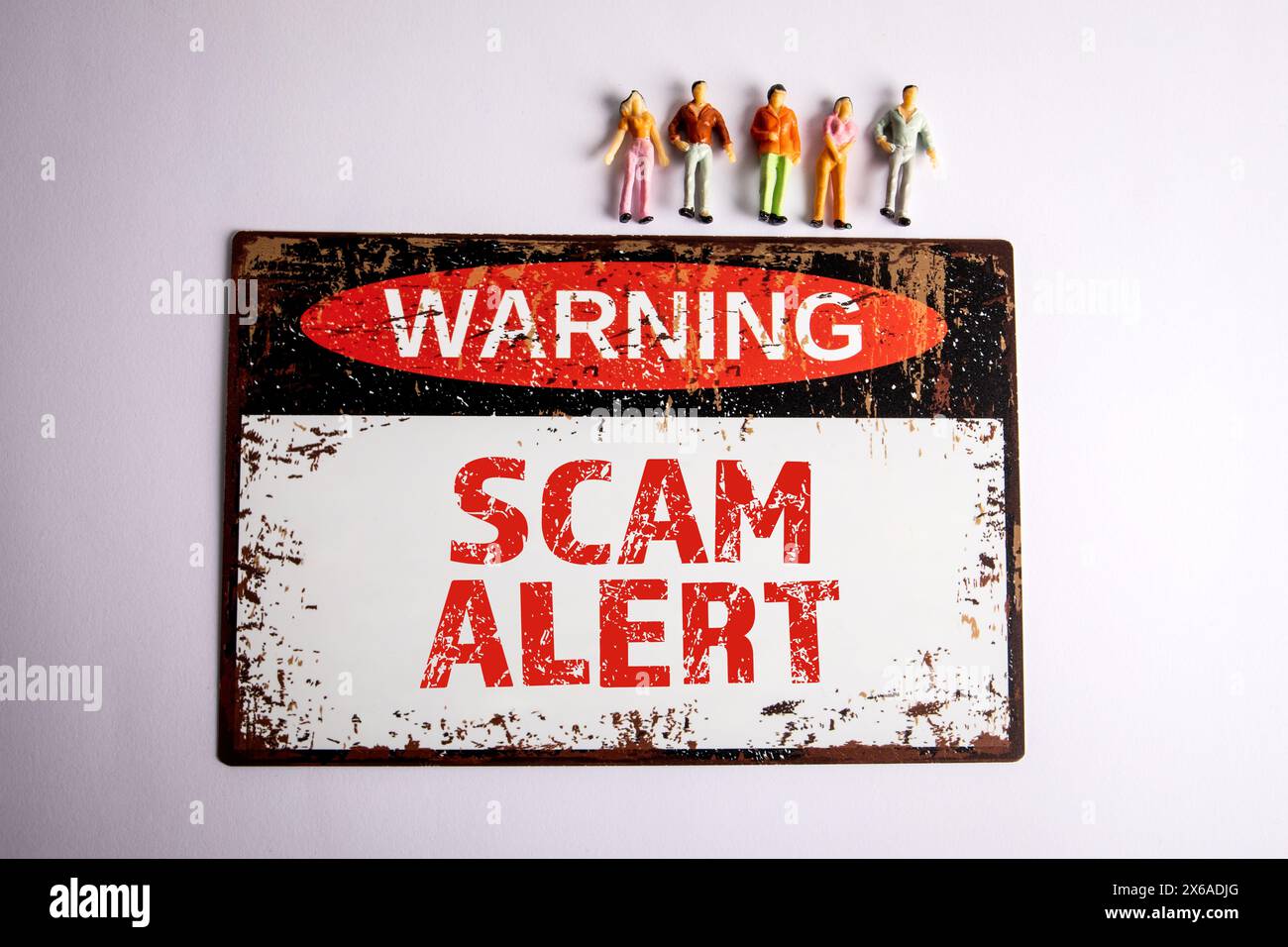 Scam Alert. Warning sign and miniature people on a white background ...