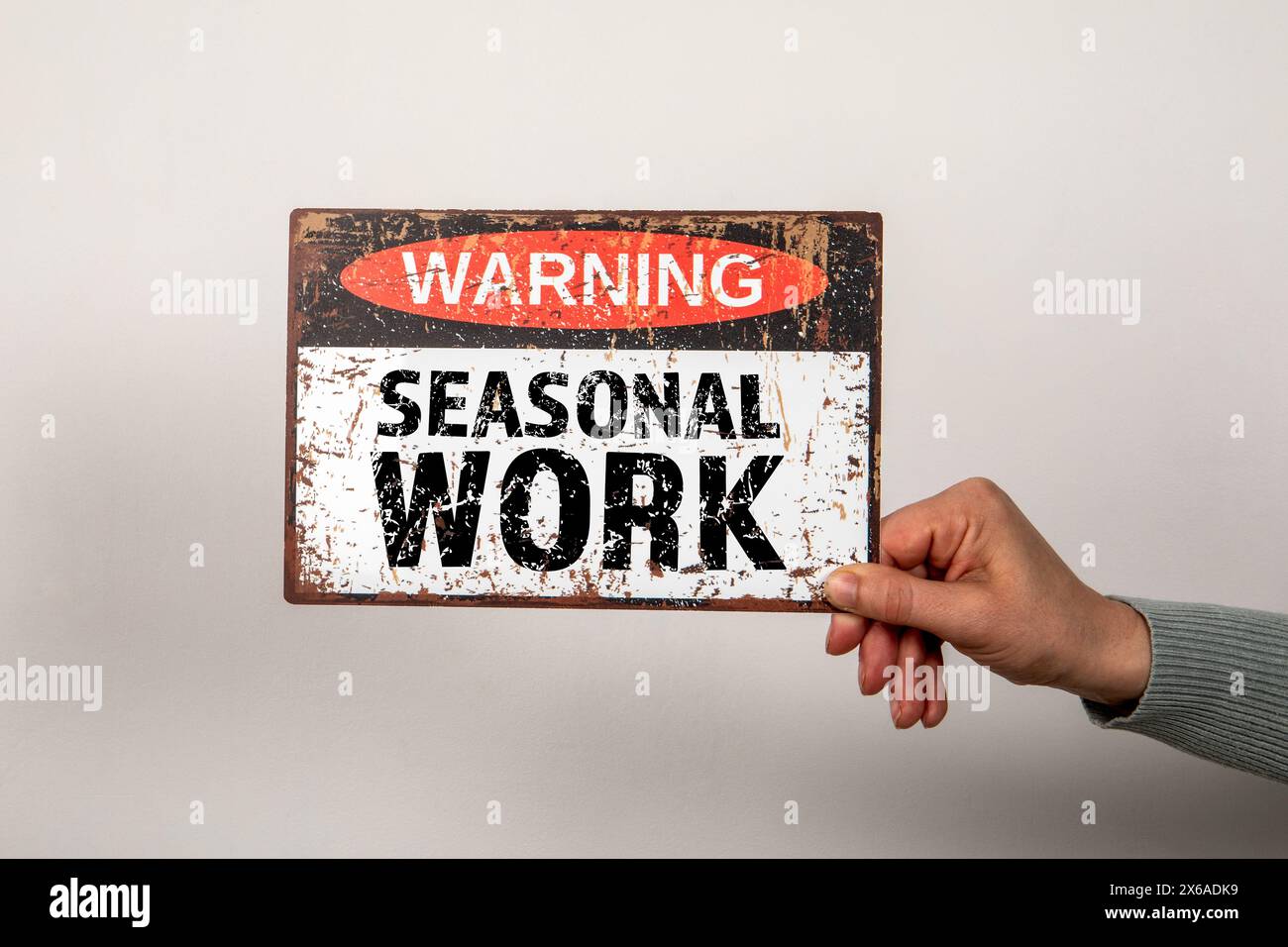 Seasonal Work. Warning sign with text in hands on light background ...