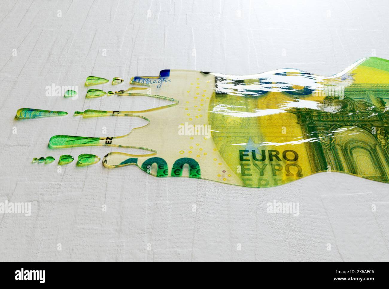A concept image showing a regular European Euro banknote that is melted ...