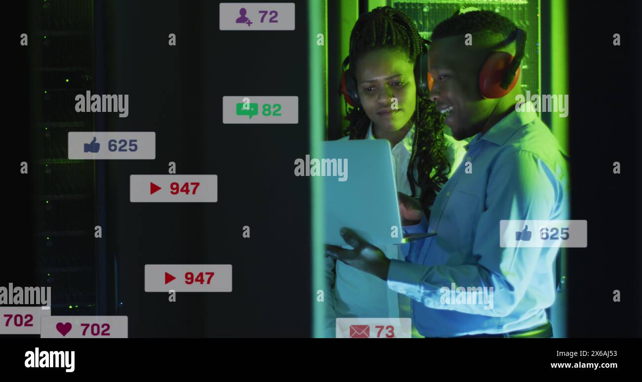 Image of social media icons and numbers over diverse it technicians by computer servers Stock ...