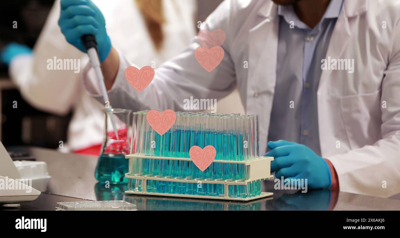 Image of hearts over caucasian male scientist using pipette in lab ...