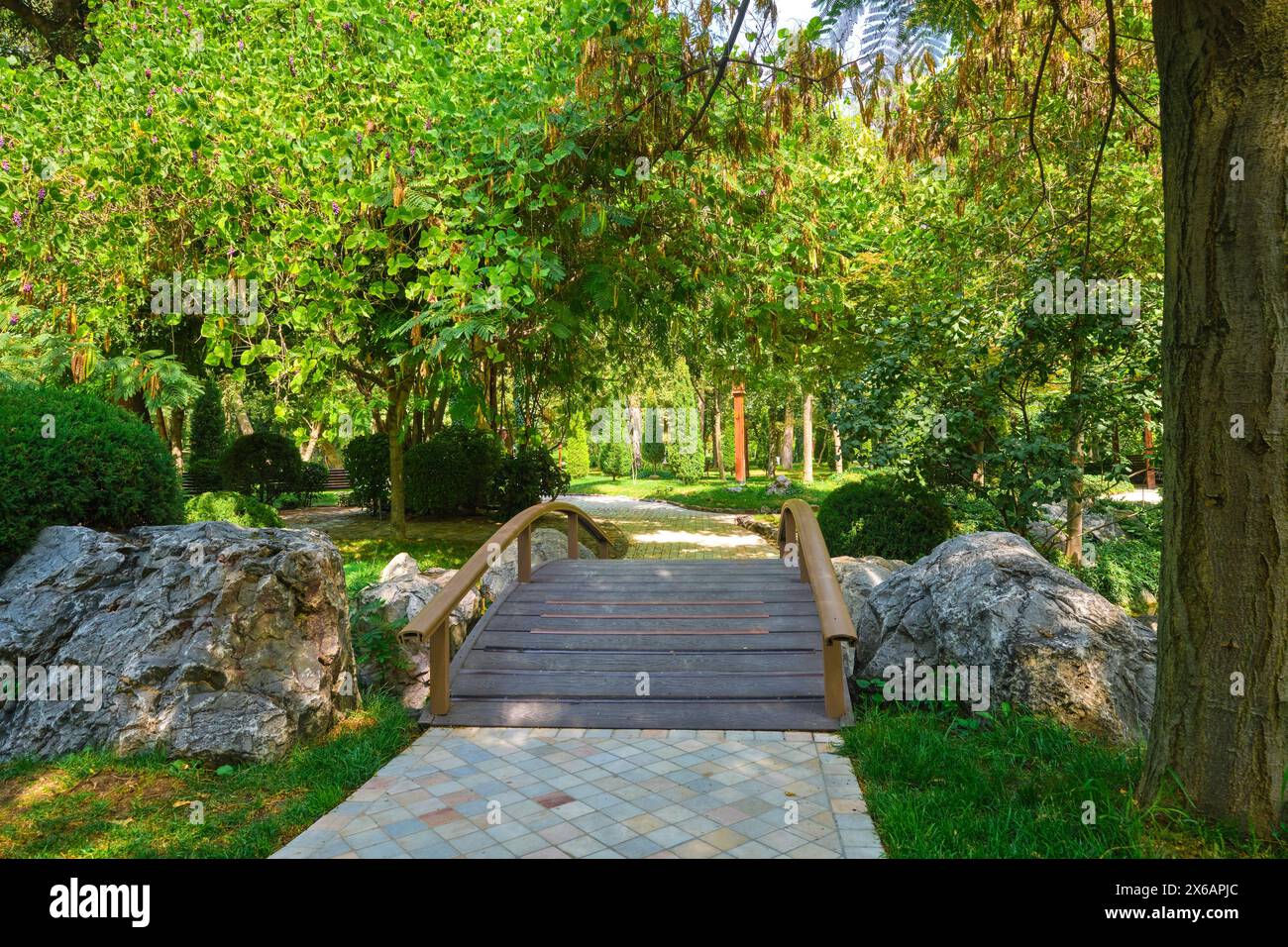 An arched, curved pedestrian bridge made of wood. At the traditional ...