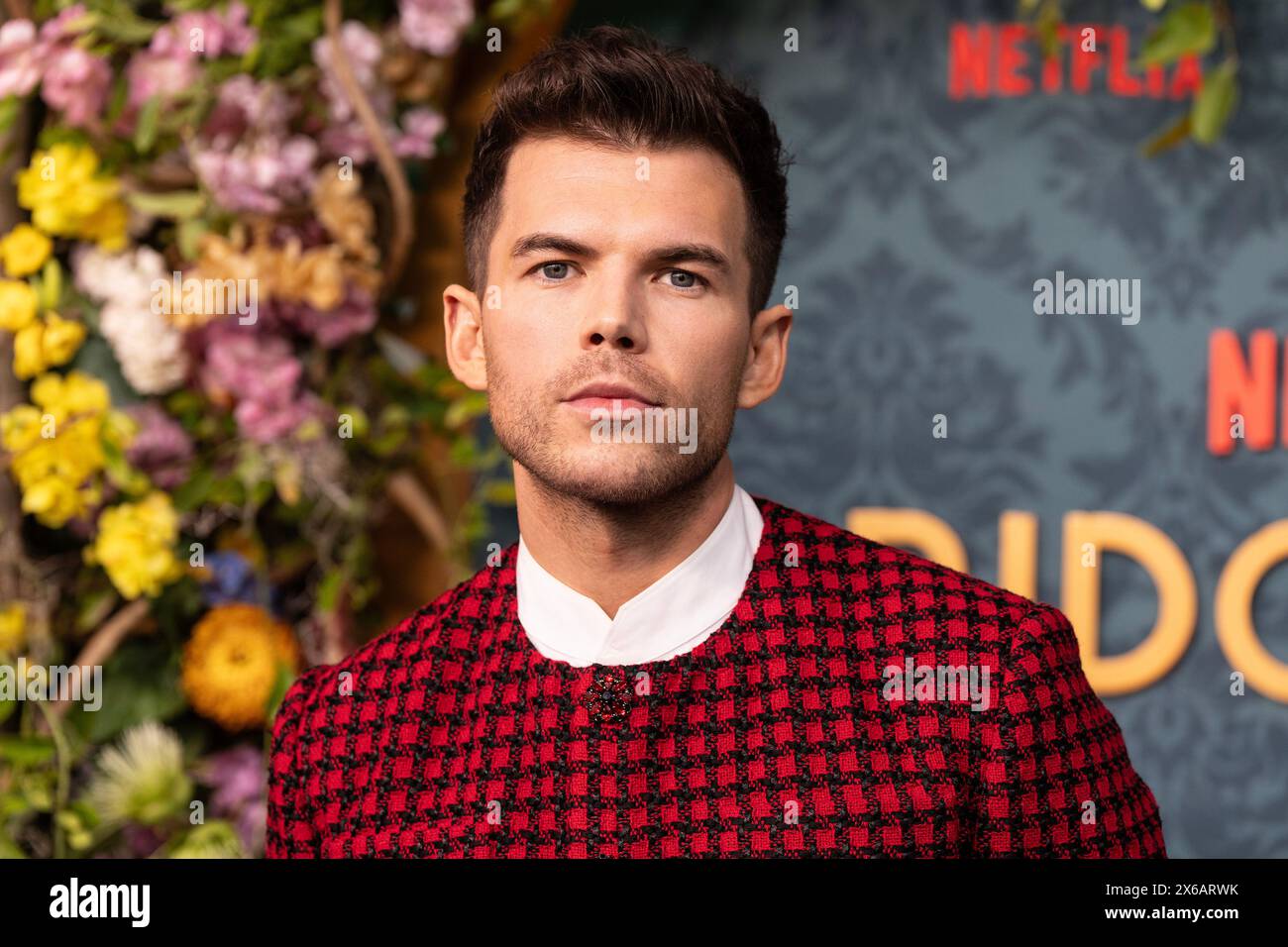 Luke Newton wearing dress by Versace and wrist watch by Chopard attends ...