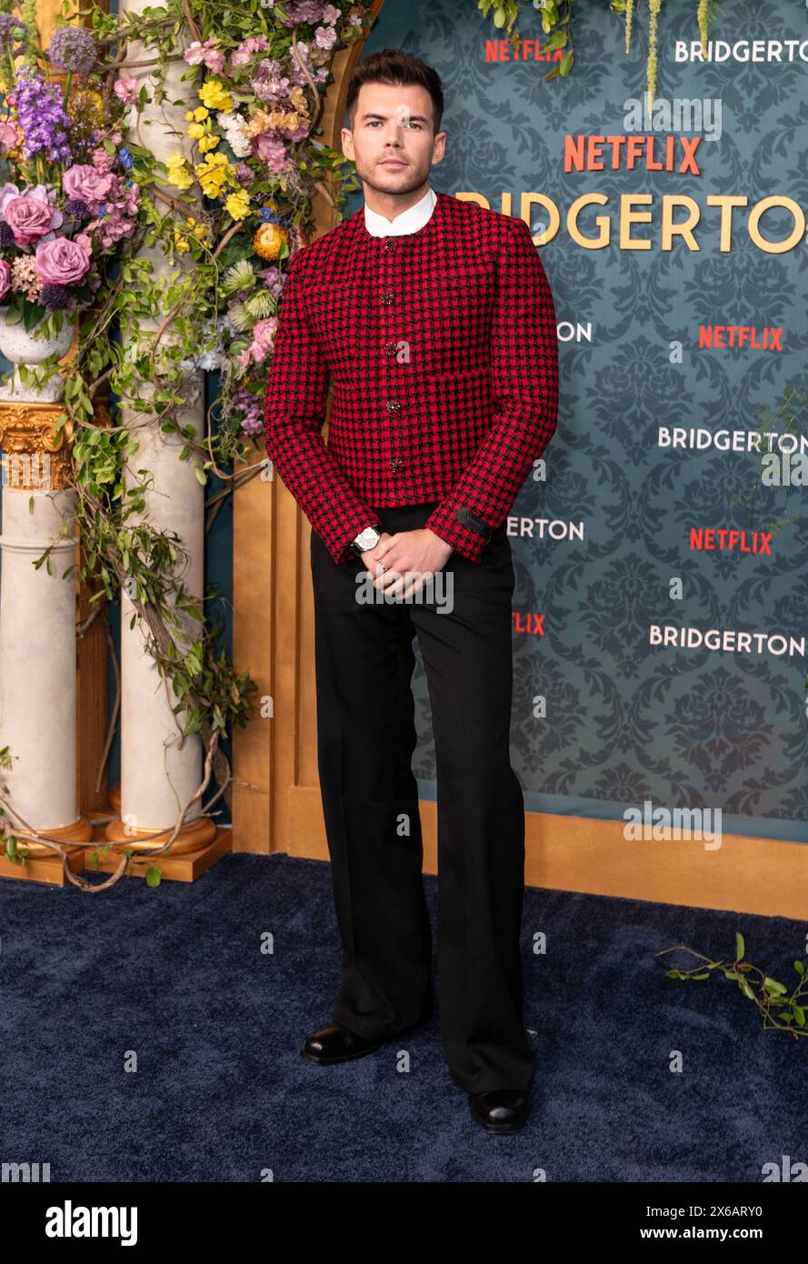 Luke Newton wearing dress by Versace and wrist watch by Chopard attends ...