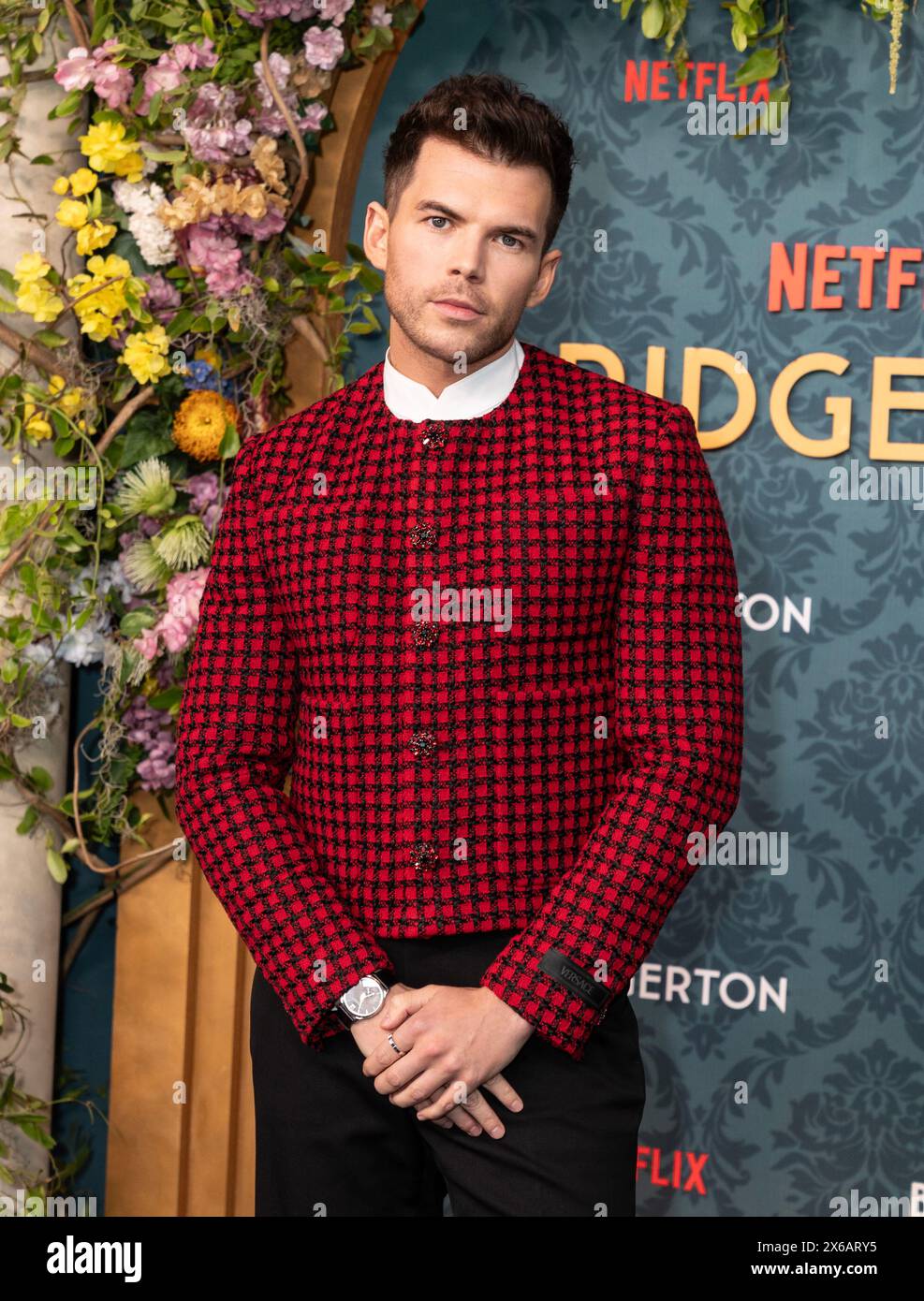 Luke Newton wearing dress by Versace and wrist watch by Chopard attends ...