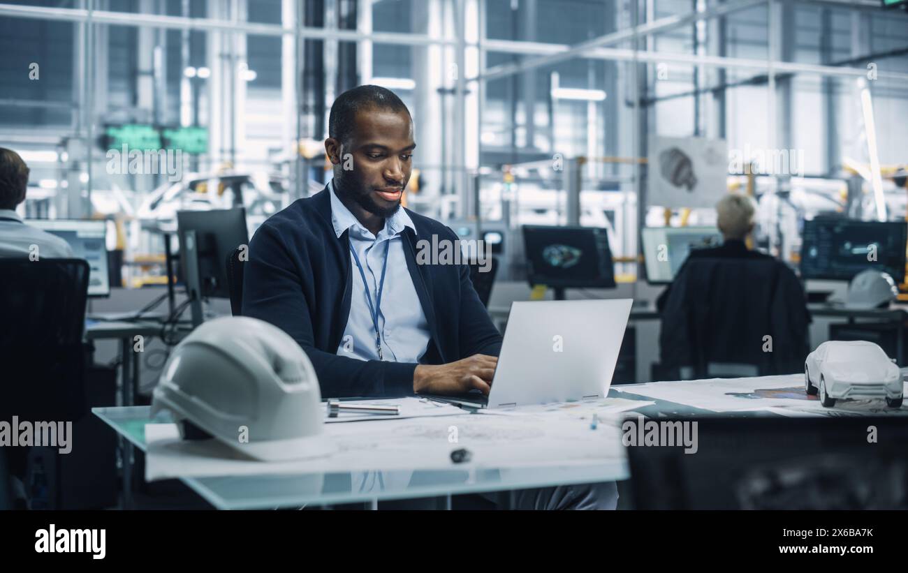 Young African American Engineer Working on Laptop Computer in an Office ...