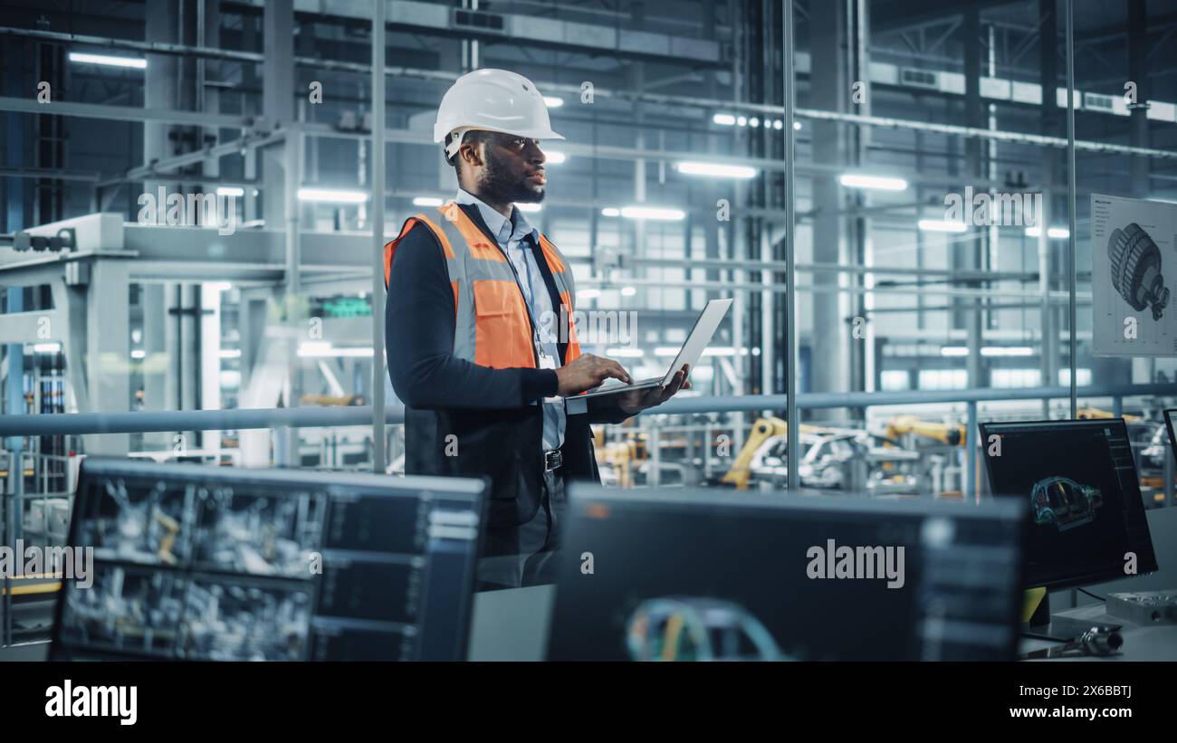 African American Engineer Using Laptop and Looking Out of the Office at ...