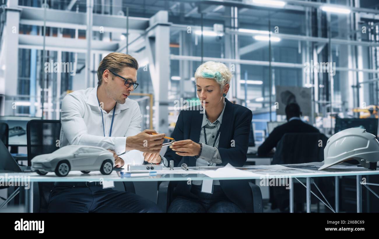 Two Young Automotive Engineers Working in Office at Car Factory ...