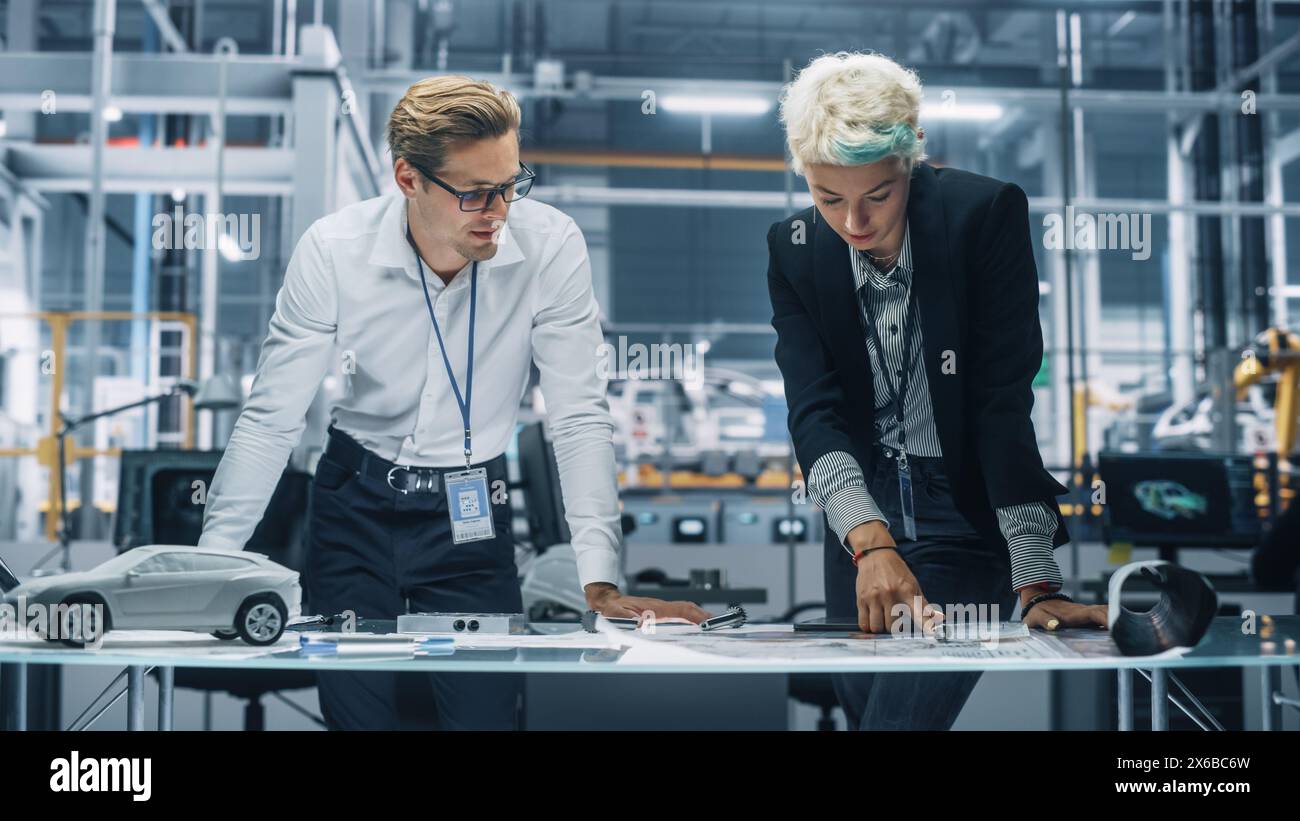 Two Young Automotive Engineers Working in Office at Car Factory ...