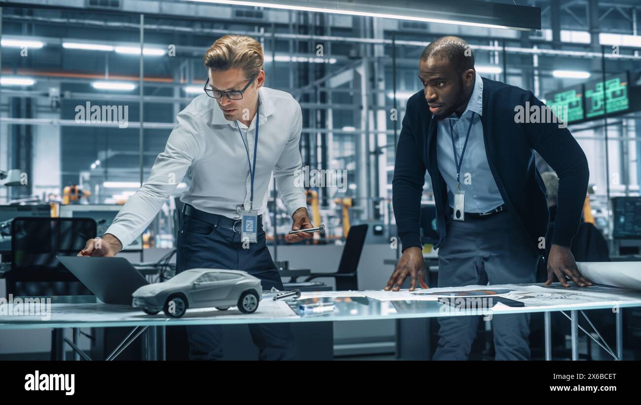 Two Automotive Engineers Working in Office at Car Factory. Industrial ...