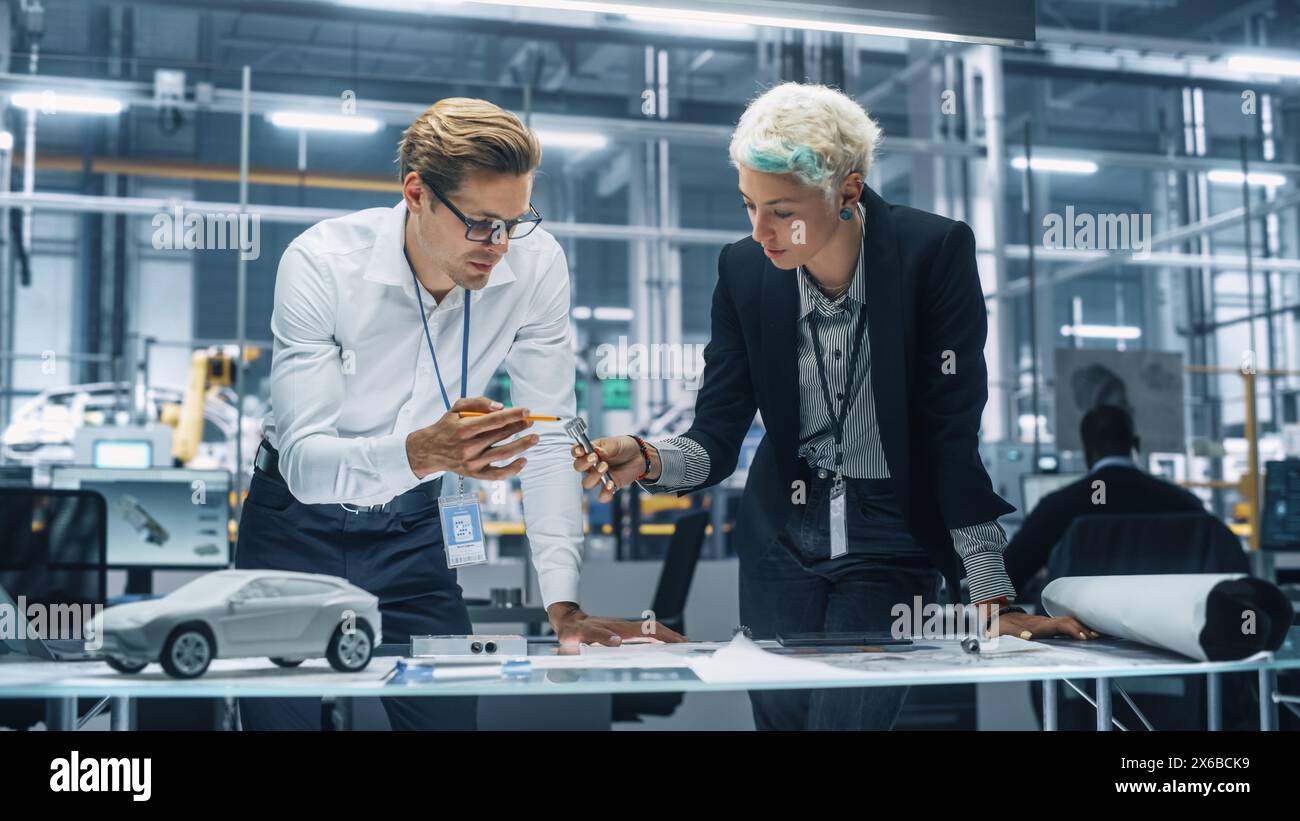 Two Young Automotive Engineers Working in Office at Car Factory ...