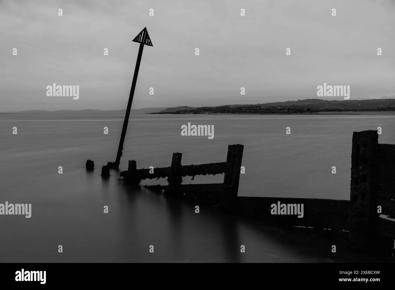 Triangular sea marker at the end of a decaying wooden groyne, Exmouth ...