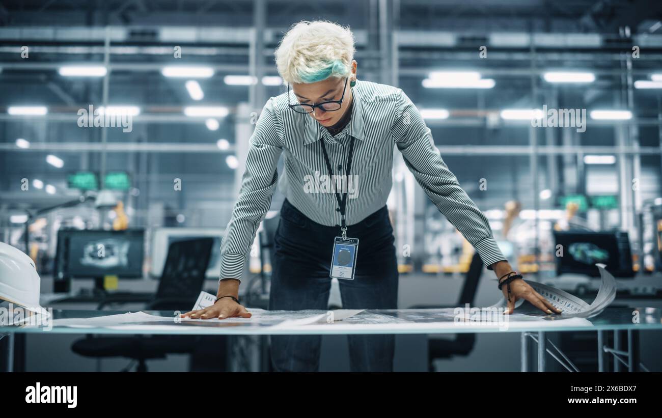 Young Diverse Female Engineer Looking at a Technical Blueprint at Work ...