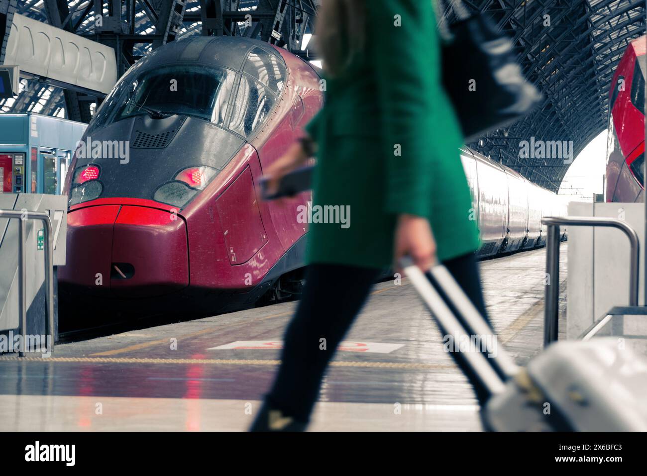 Train and passing person in railroad station Stock Photo - Alamy