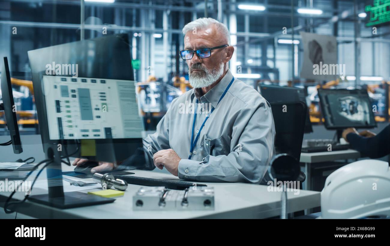 Car Factory Office: Portrait of Senior Male Chief Engineer Working on ...