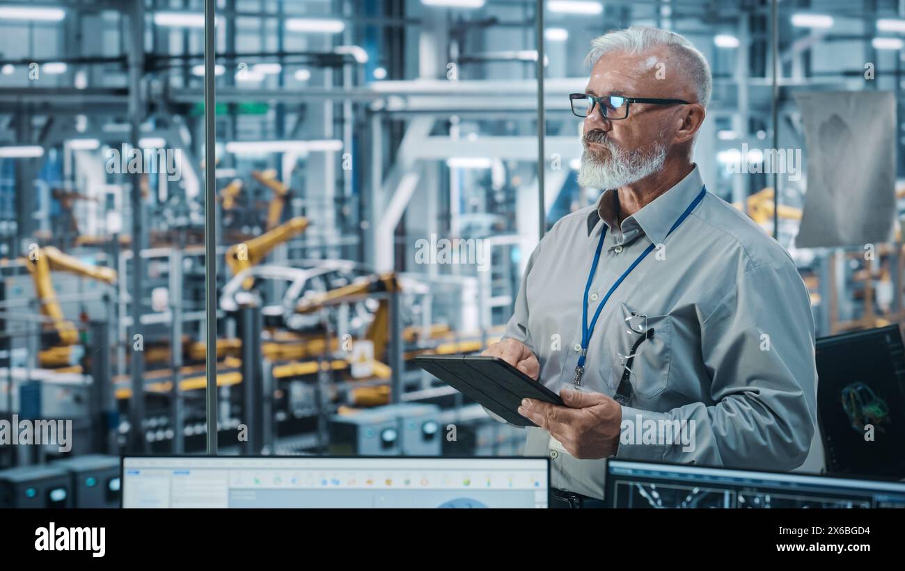 Car Factory Office: Portrait of Senior White Male Chief Engineer Using Tablet Computer in ...