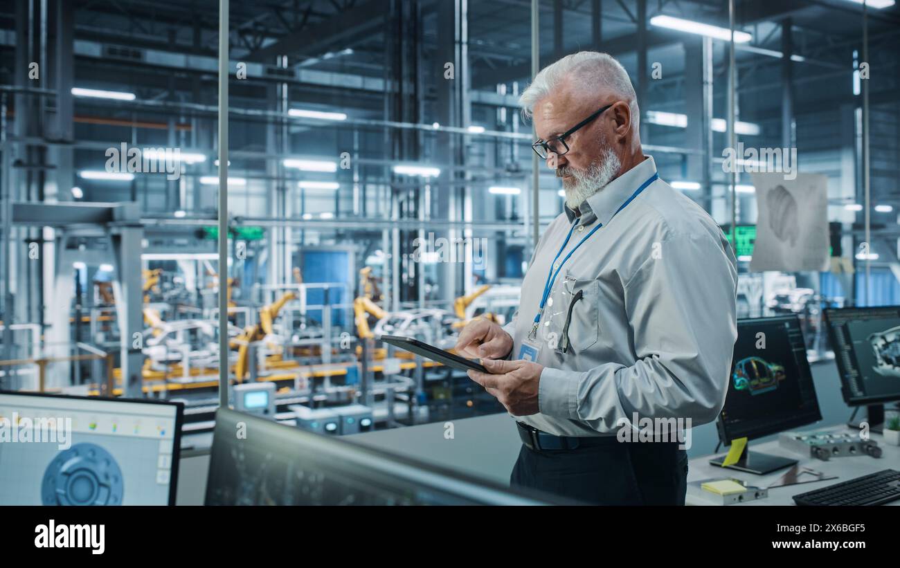 Car Factory Office: Portrait of Senior White Male Chief Engineer Using Tablet Computer in ...