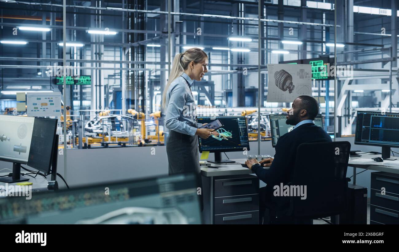 Car Factory Office: Female Supervisor Talks with Male Automotive Engineer, Using Computer to ...