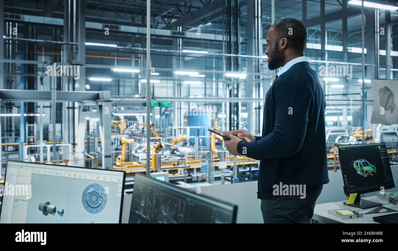 Car Factory Office: Portrait of Successful Black Male Chief Engineer Using Tablet Computer in ...