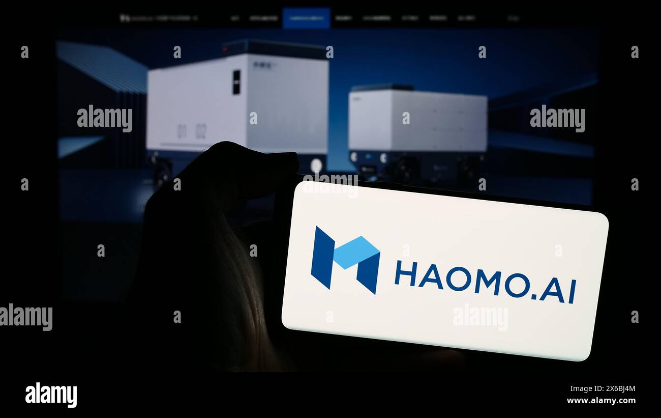 Person holding mobile phone with logo of Chinese autonomous driving ...